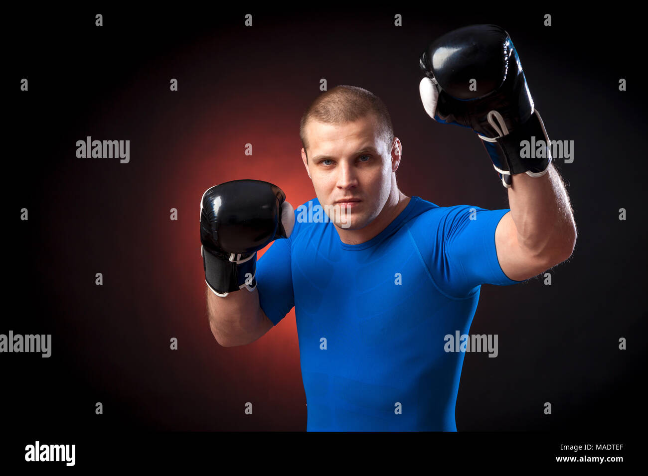 A strong dark-haired sportman boxer in a blue sports wear rush guard ...