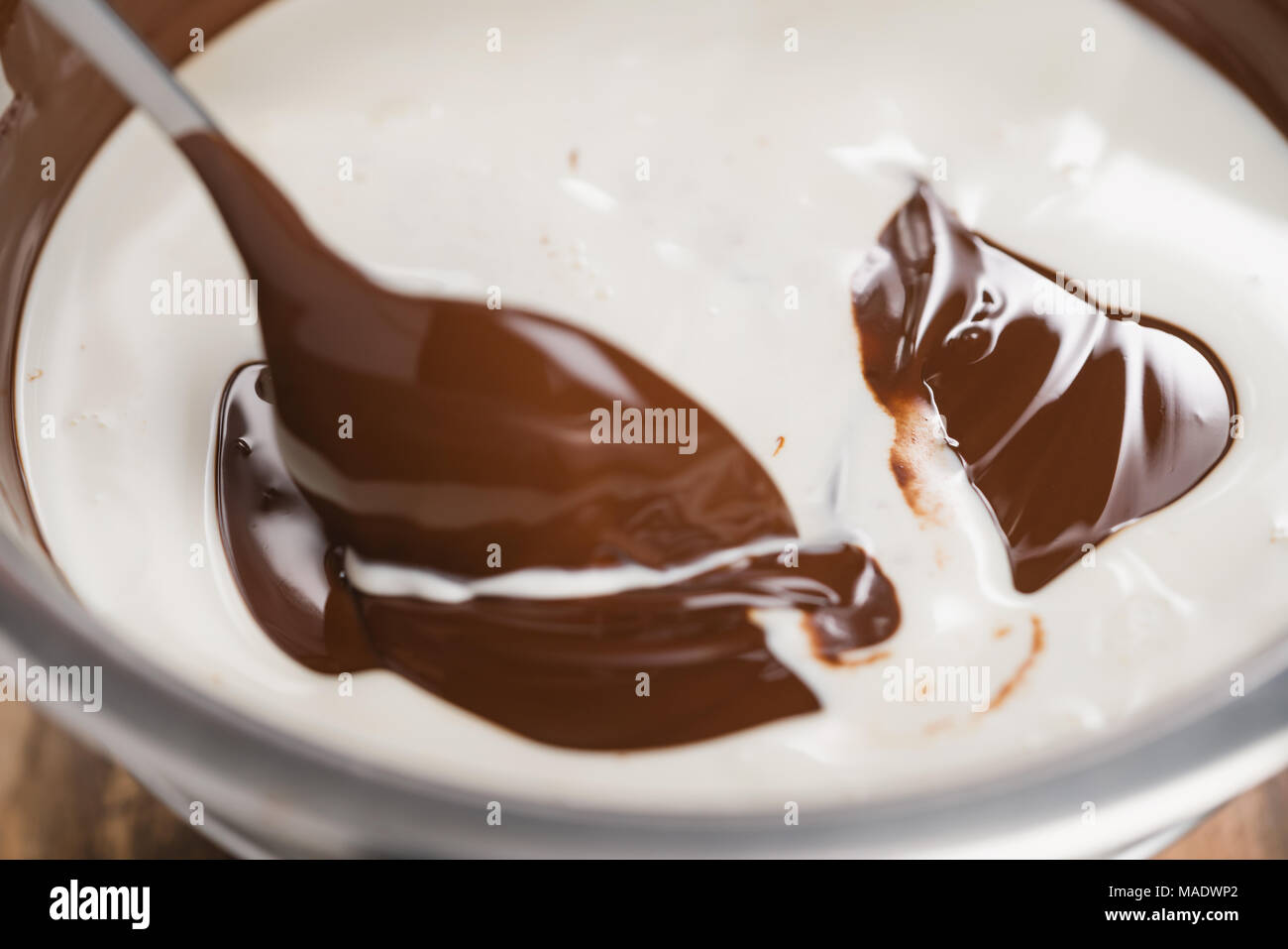 mixing cream into melted chocolate, cooking process Stock Photo - Alamy