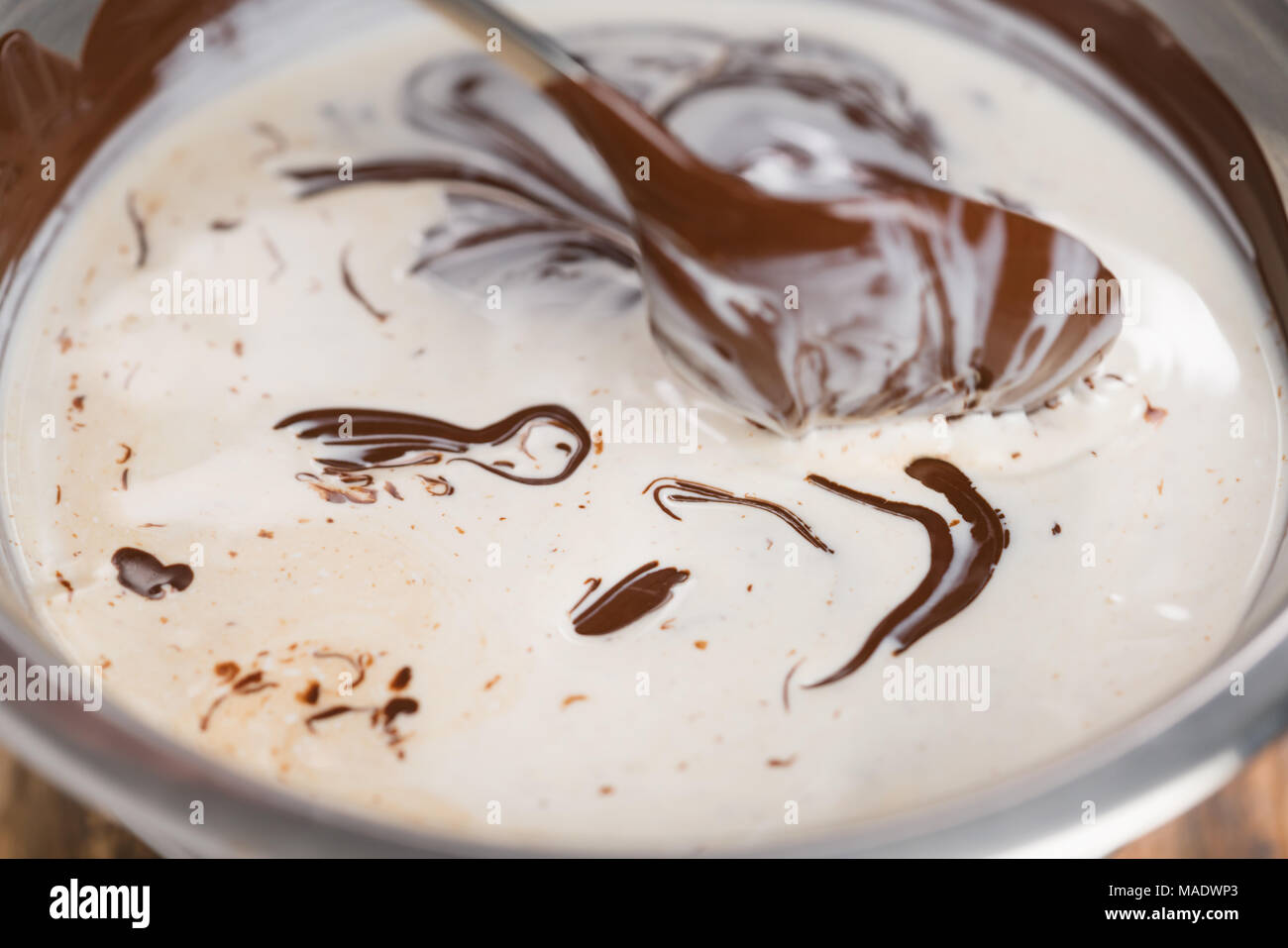 mixing cream into melted chocolate, cooking process Stock Photo - Alamy