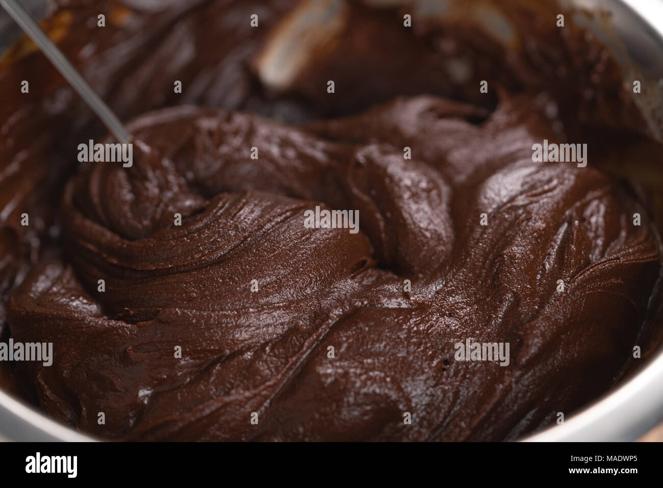 mixing cream into melted chocolate, cooking process Stock Photo - Alamy