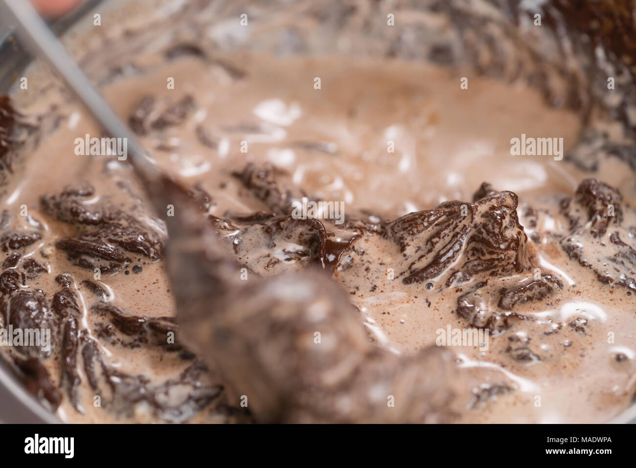 mixing cream into melted chocolate, cooking process Stock Photo - Alamy