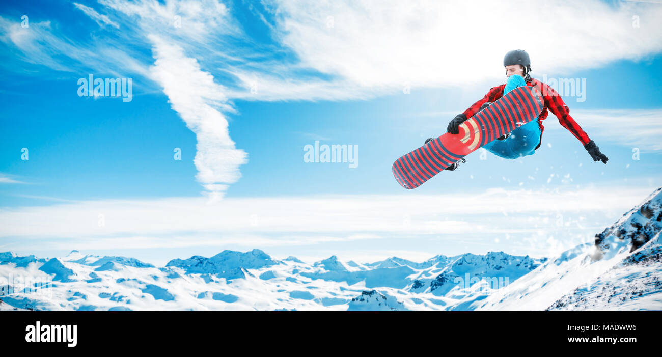 Panoramic photo of athlete jumping on snowboard at background of snowy ...