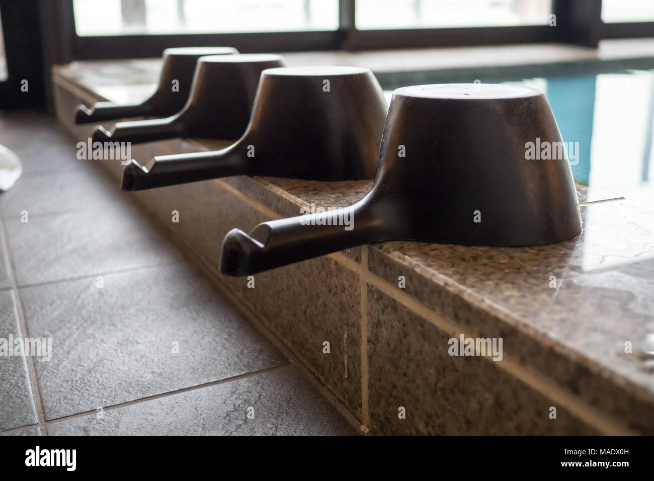 Black wooden onsen bath ladles neatly placed in a row Stock Photo - Alamy