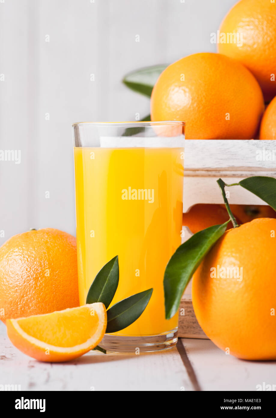 Glass of organic fresh orange smoothie juice with raw oranges in white ...