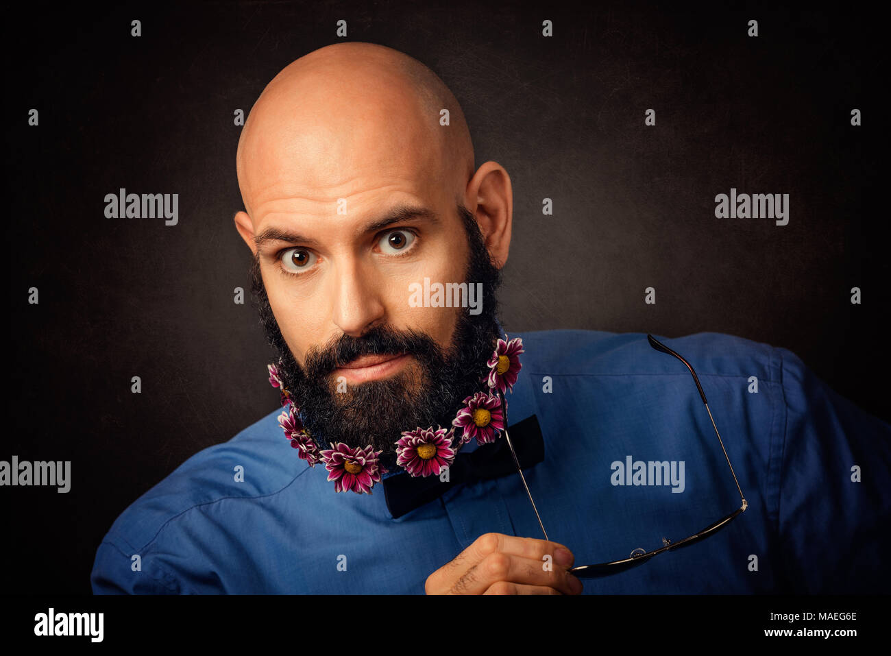 Portrait of unshaven man with beard and moustache with chrysanthemum ...