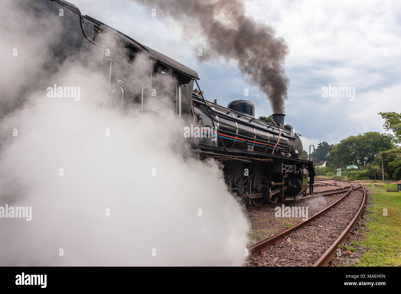 Steam train locomotive closeup exhuasts pulls out of countryside ...