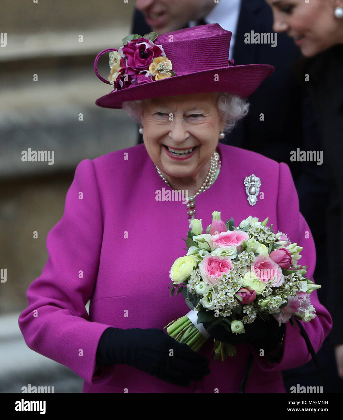 Queen Elizabeth II holds a posey as she leaves following the Easter ...