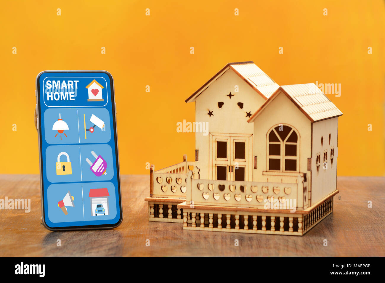 Smart home mobile screen with house miniature Stock Photo - Alamy