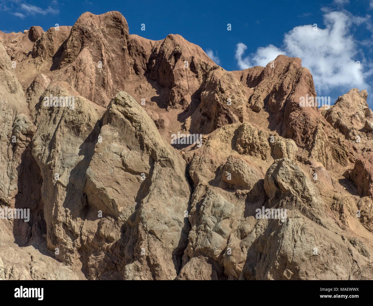 Brown rocks of relief shape and bright brown color against the blue sky ...