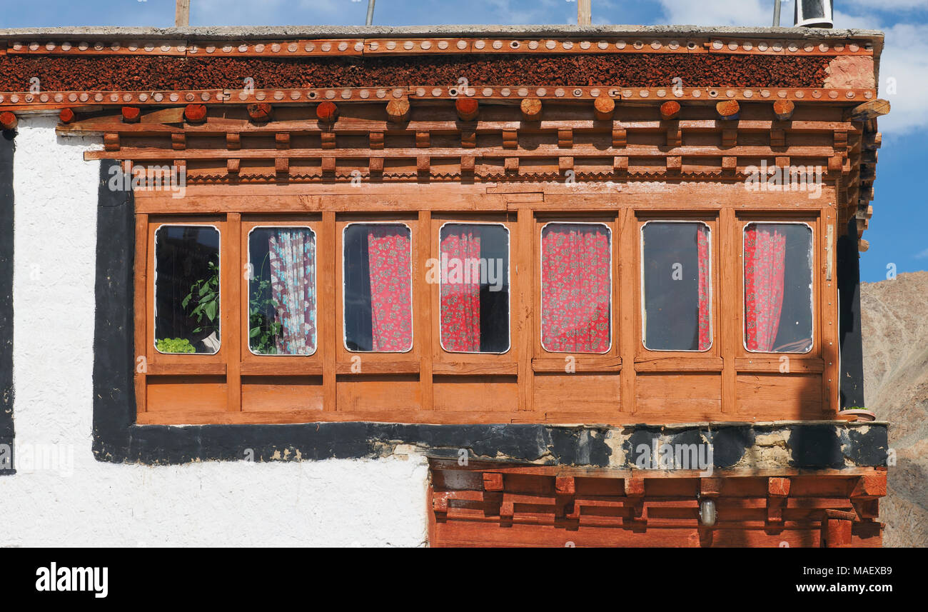 Traditional Tibetan house: brown window frames with carving inside a ...