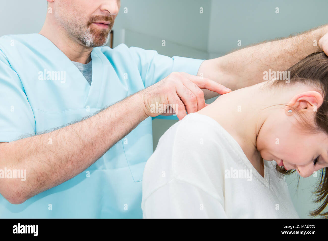 Close up Male neurologist doctor examines cervical vertebrae of female ...
