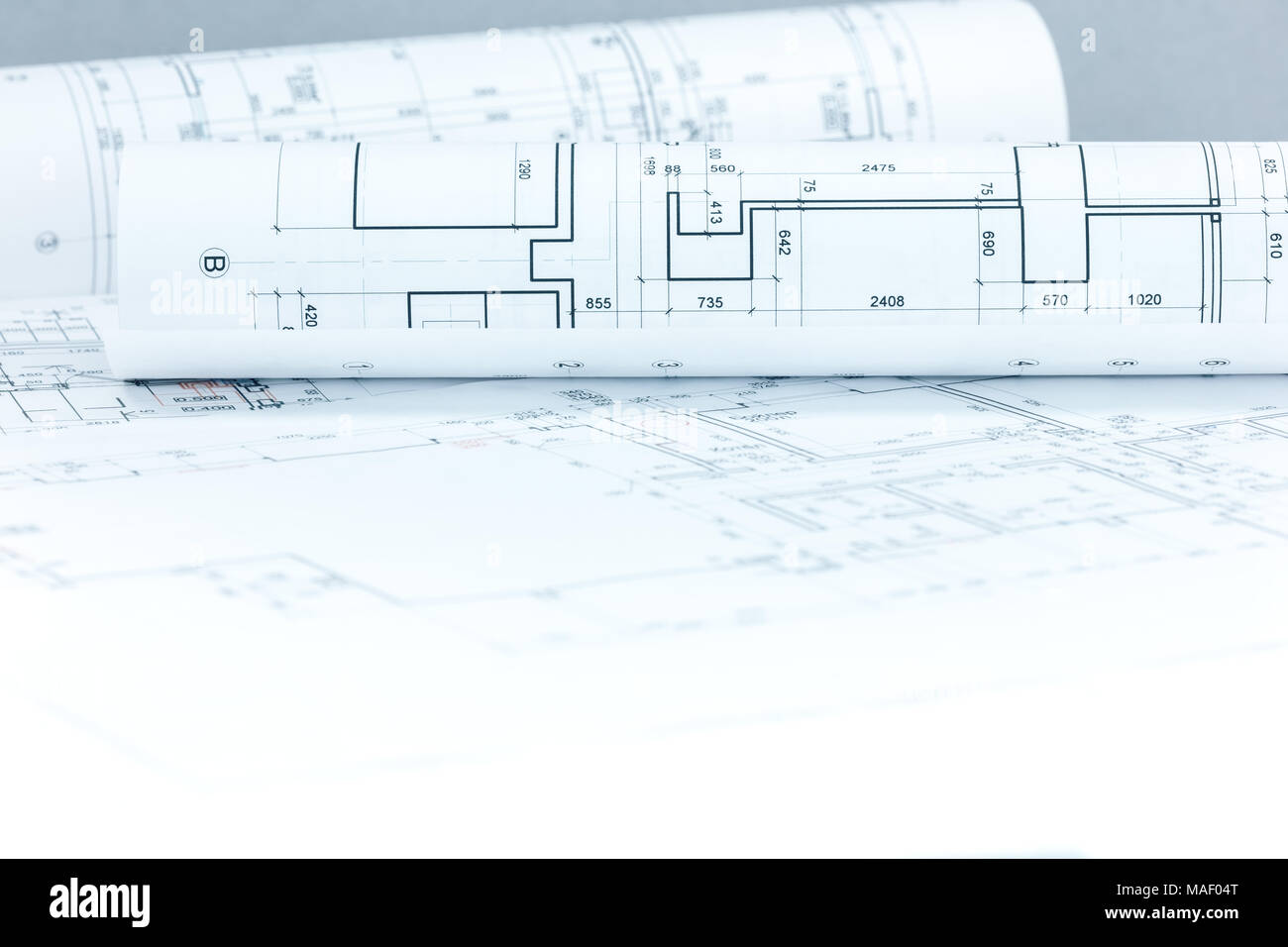 architectural project drawings and blueprints rolls on desk as ...
