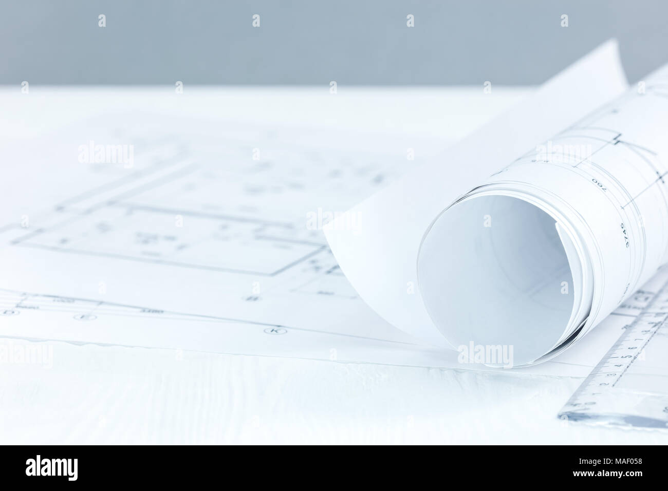 architect blueprint rolls and construction plans with ruler on desk ...