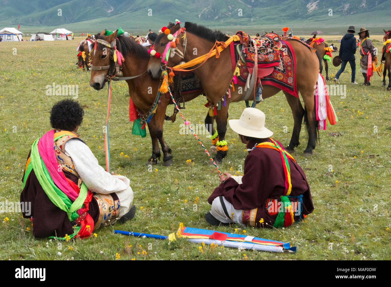 Tibetan people in traditional clothing with horses at Horse Race ...