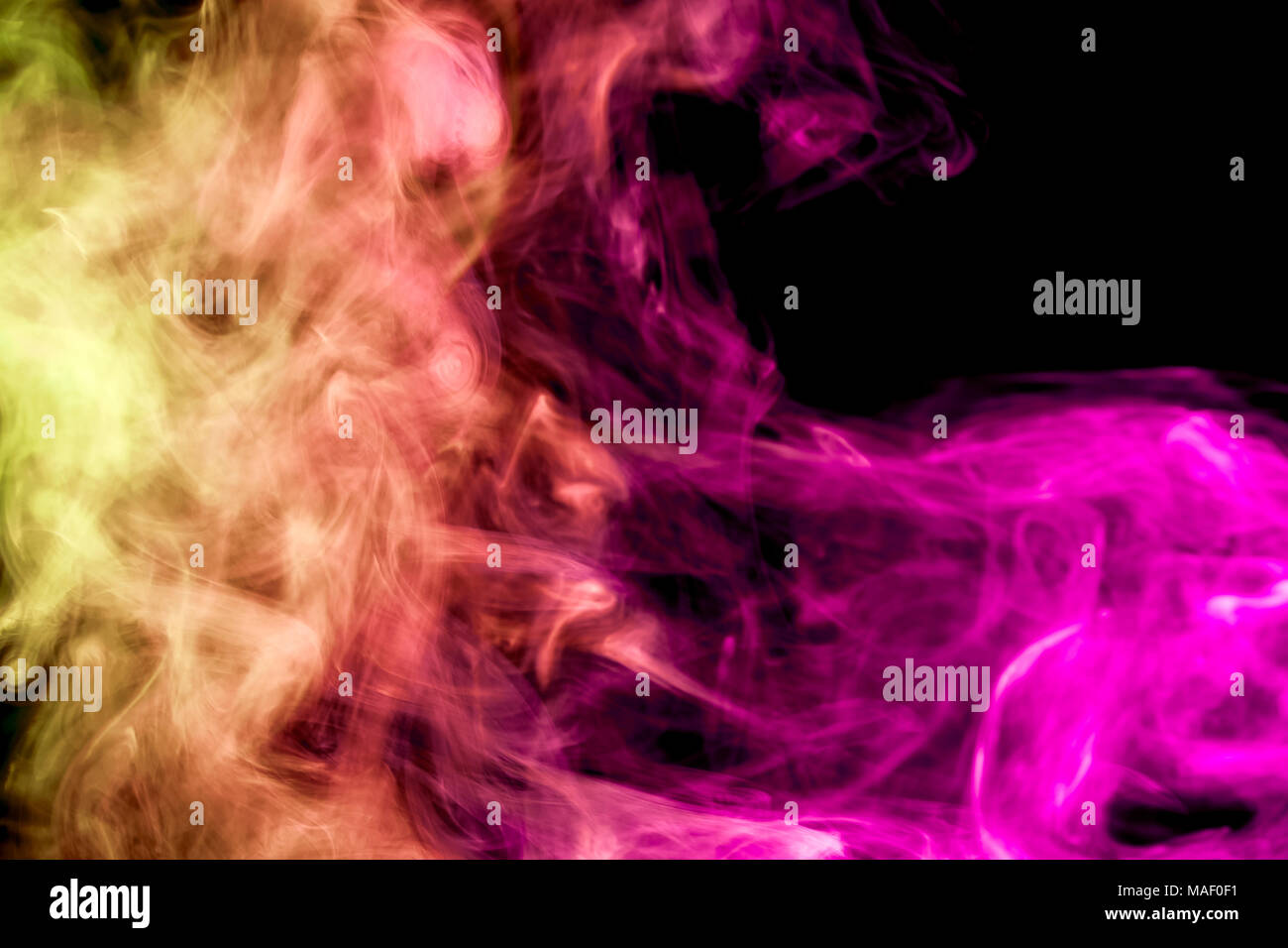 Colorful yellow and pink smoke on a black isolated background ...