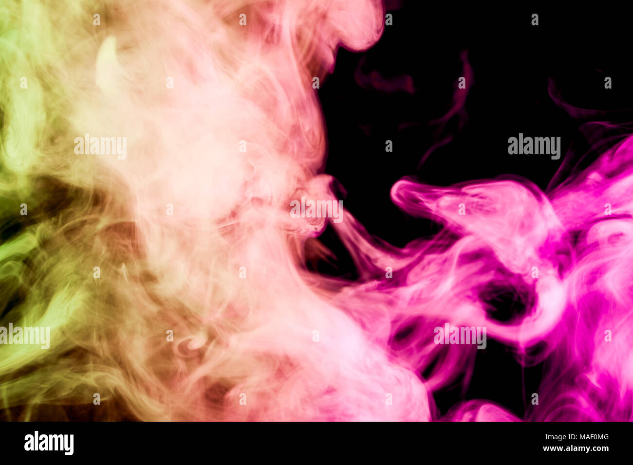 Dense multicolored smoke of yellow, pink and purple colors on a black ...