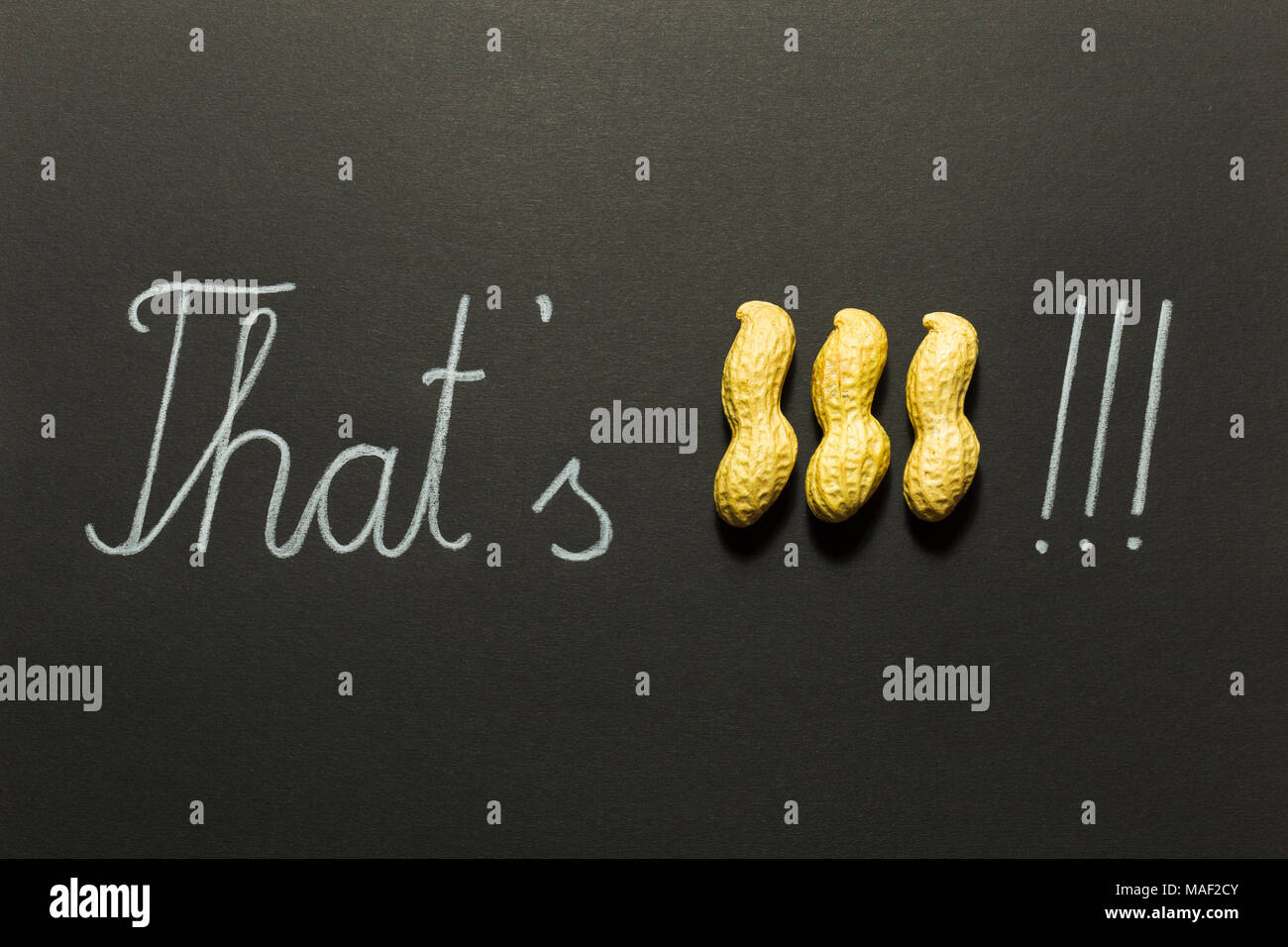 Concept of the saying that's peanuts! Raw unpeeled peanuts and white ...