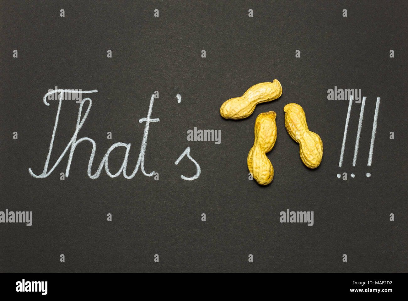 Concept of the saying that's peanuts! Raw unpeeled peanuts and white ...