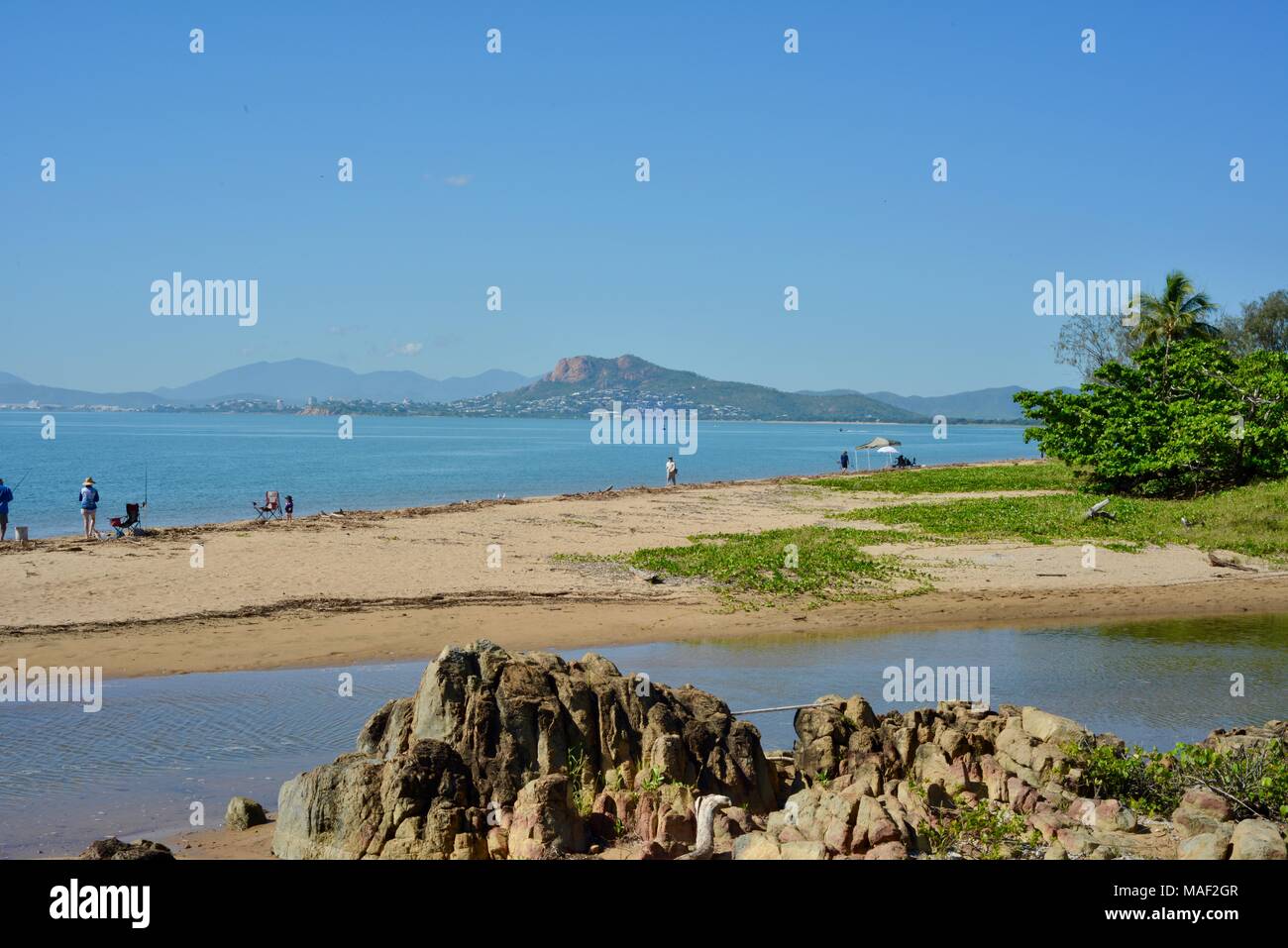 People fishing from the beach with a view of castle hill from ...