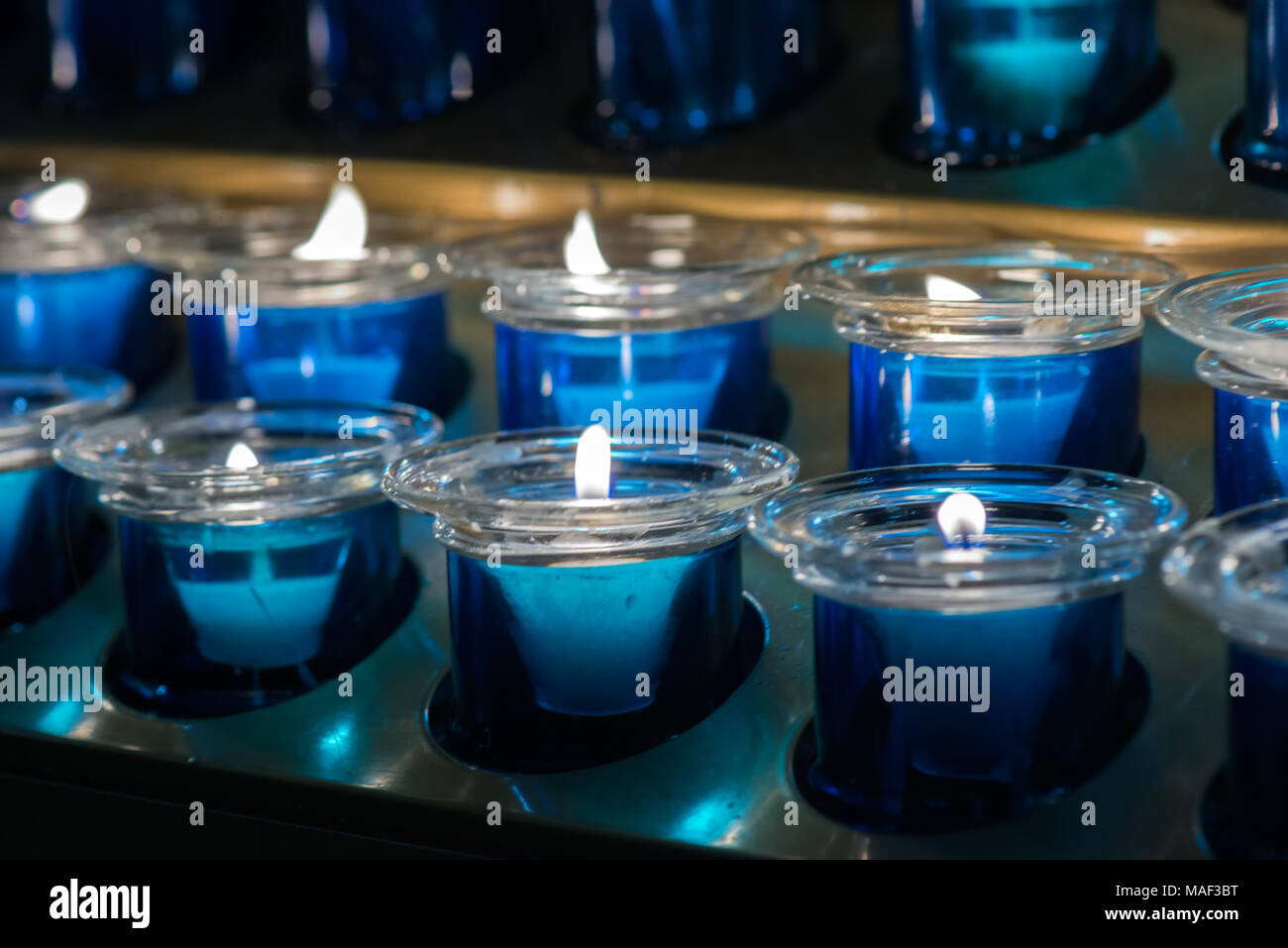 Many Blue Wax Candle in Glass. Close-up. Candle light in a straight ...