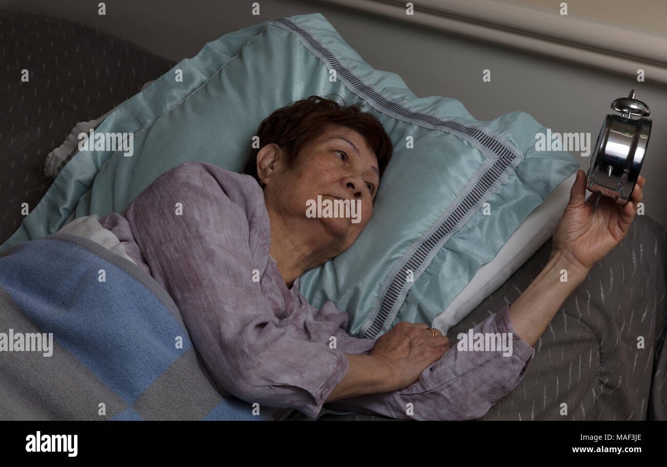 Mature woman bed alarm clock hi-res stock photography and images - Alamy