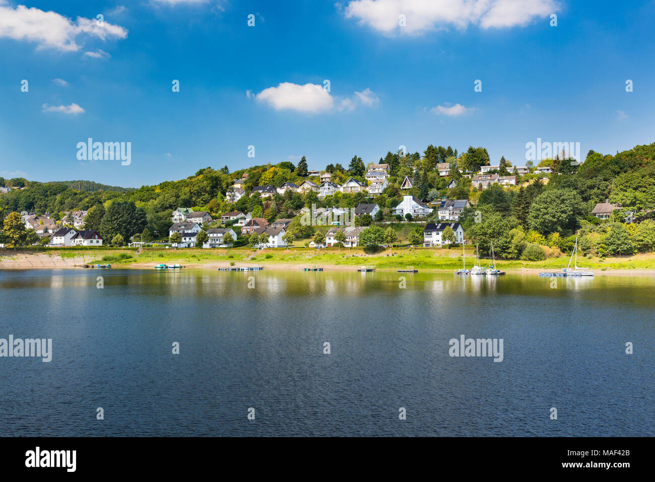 Rurberg lake front at Lake Rursee with perfect blue sky and marinas in ...