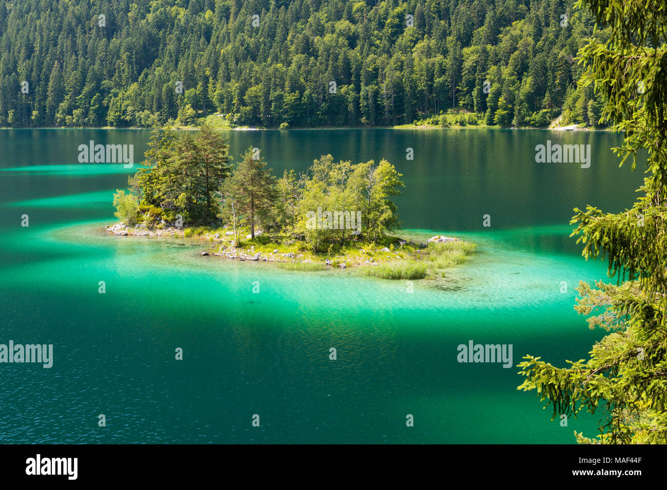 Lake Eibsee with turquoise color and an island near the Wetterstein in ...