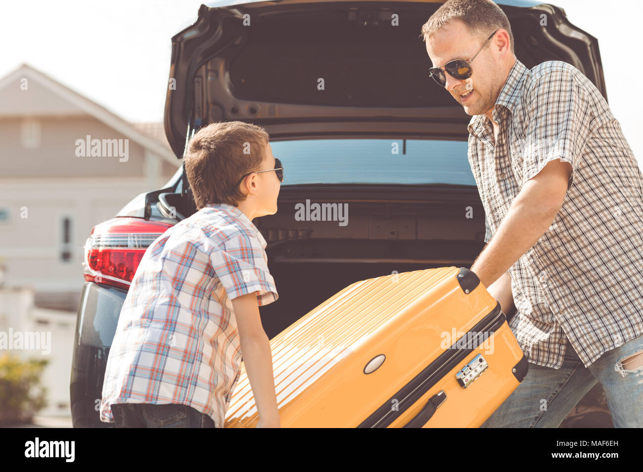 Happy father and son getting ready for road trip on a sunny day ...