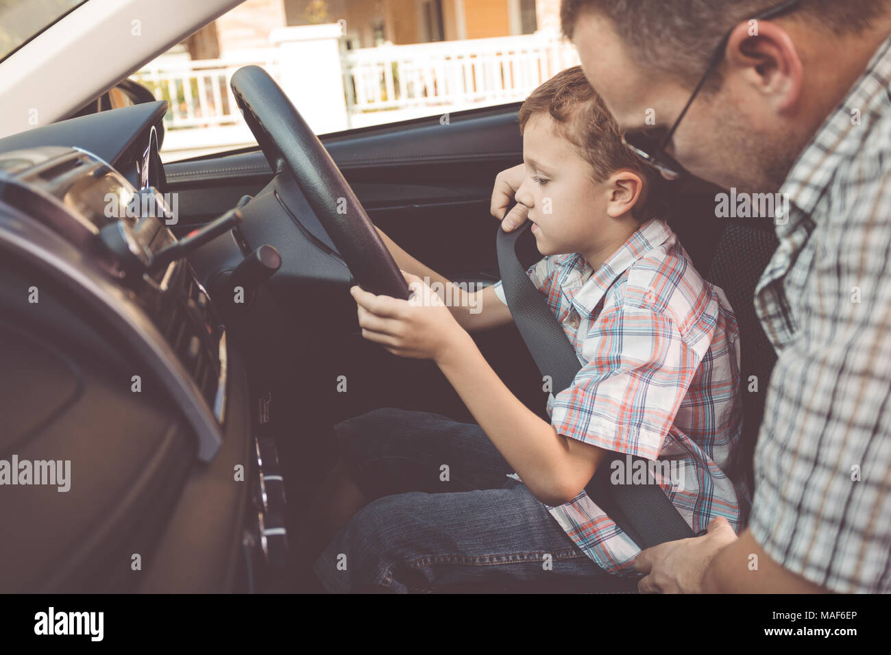 Happy father and son sitting in the car at the day time. People getting ...