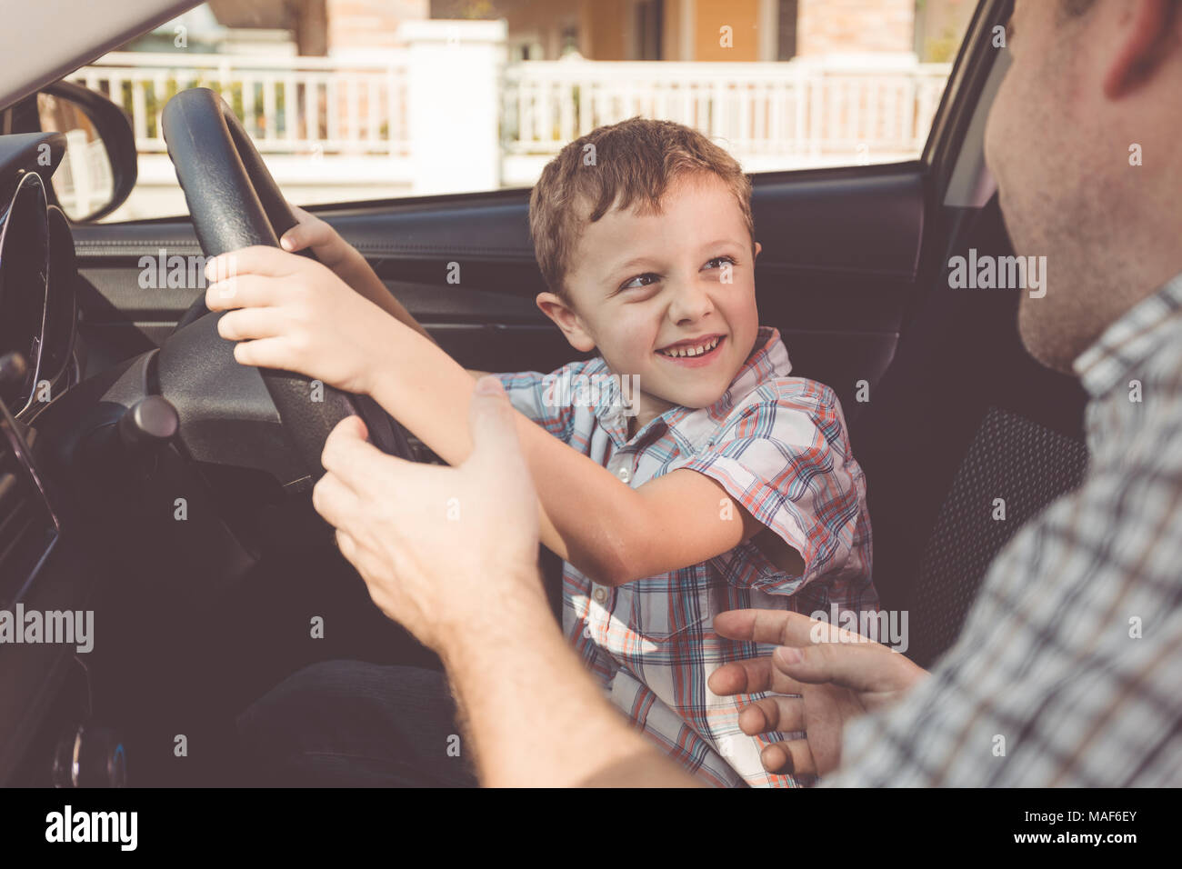 Happy father and son sitting in the car at the day time. People getting ...