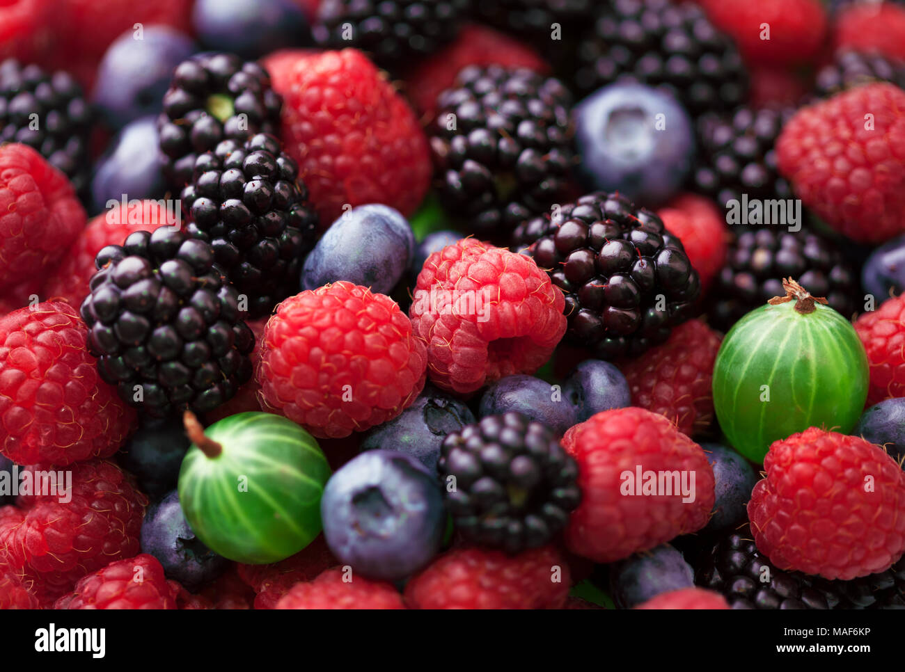 Blueberries, raspberries, blackberries and gooseberries background shot ...