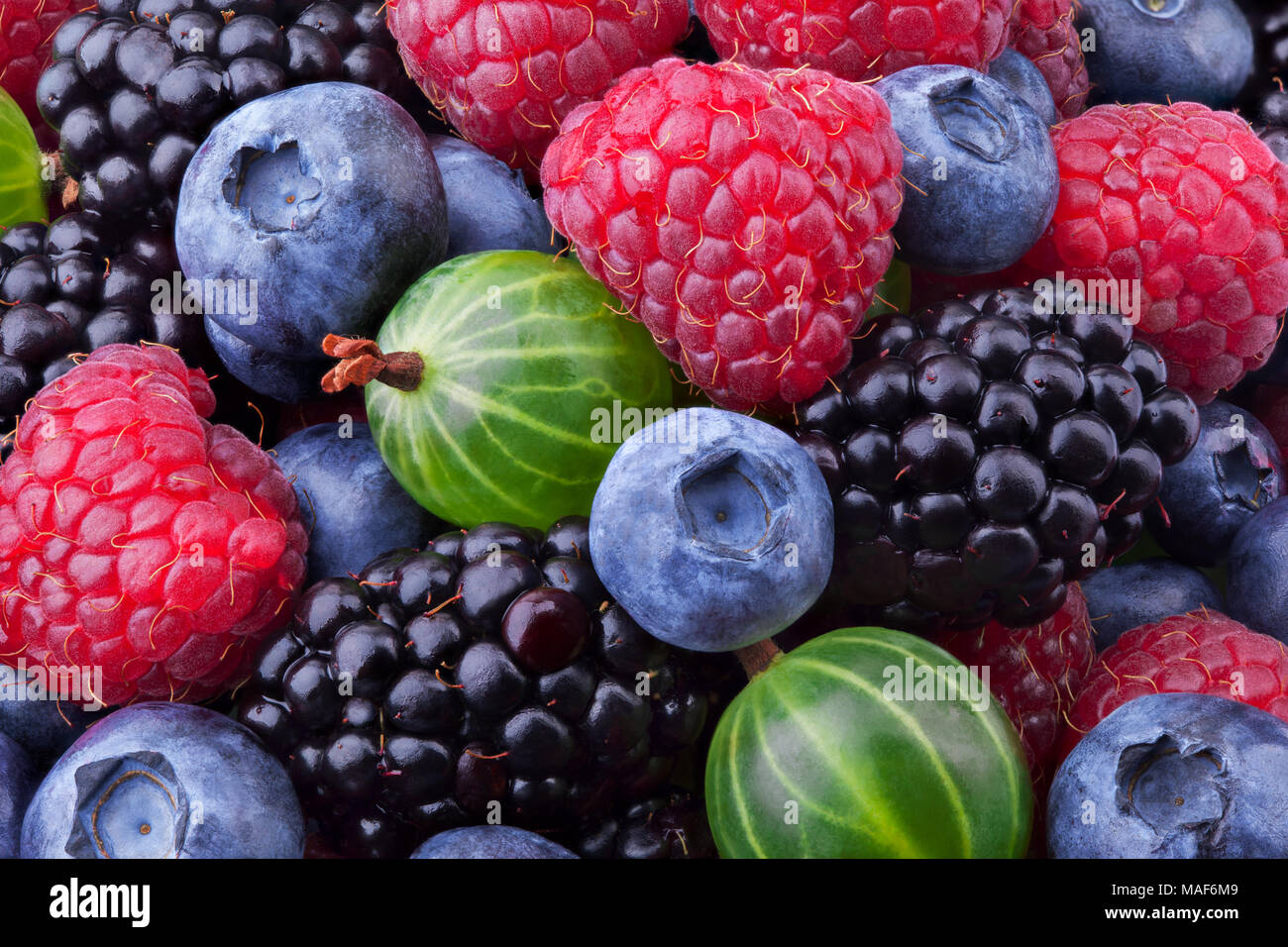 Blueberries, raspberries, blackberries and gooseberries background shot ...