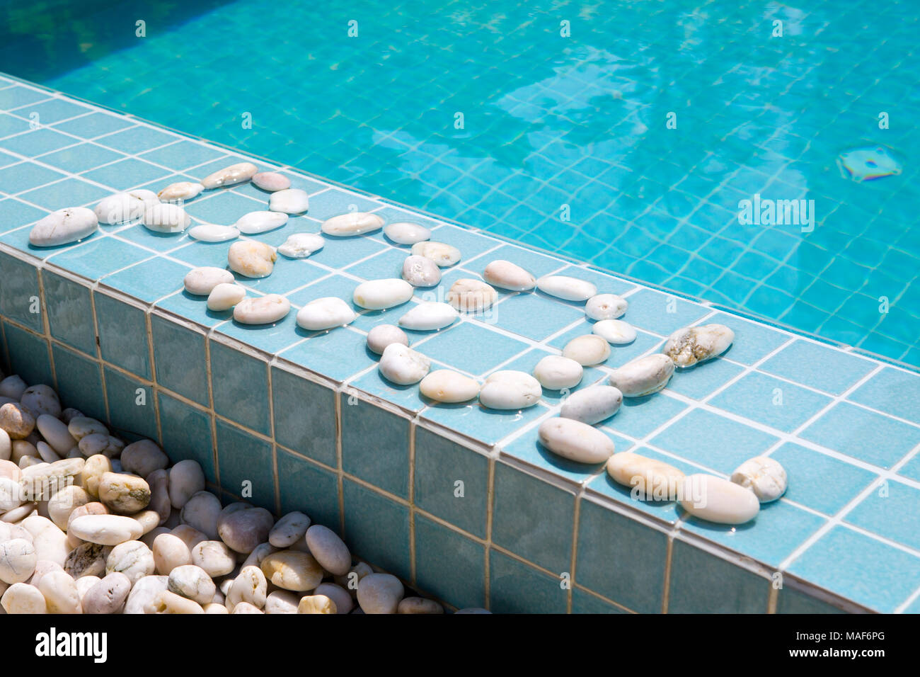 Inscription "pool" is laid out by pebble on a pool side Stock Photo - Alamy