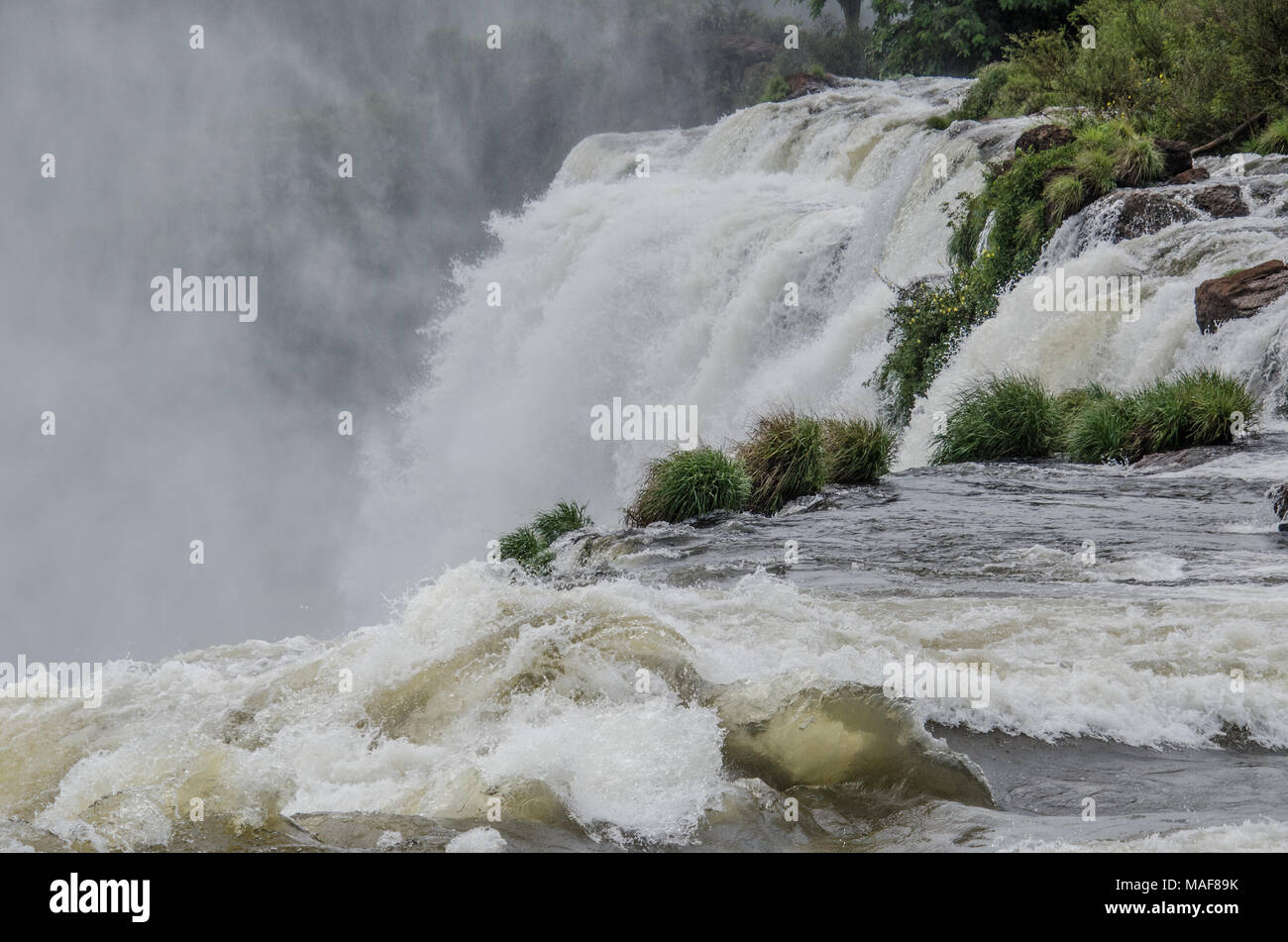 Water cascading over top of waterfall with mist rising. Beautiful ...