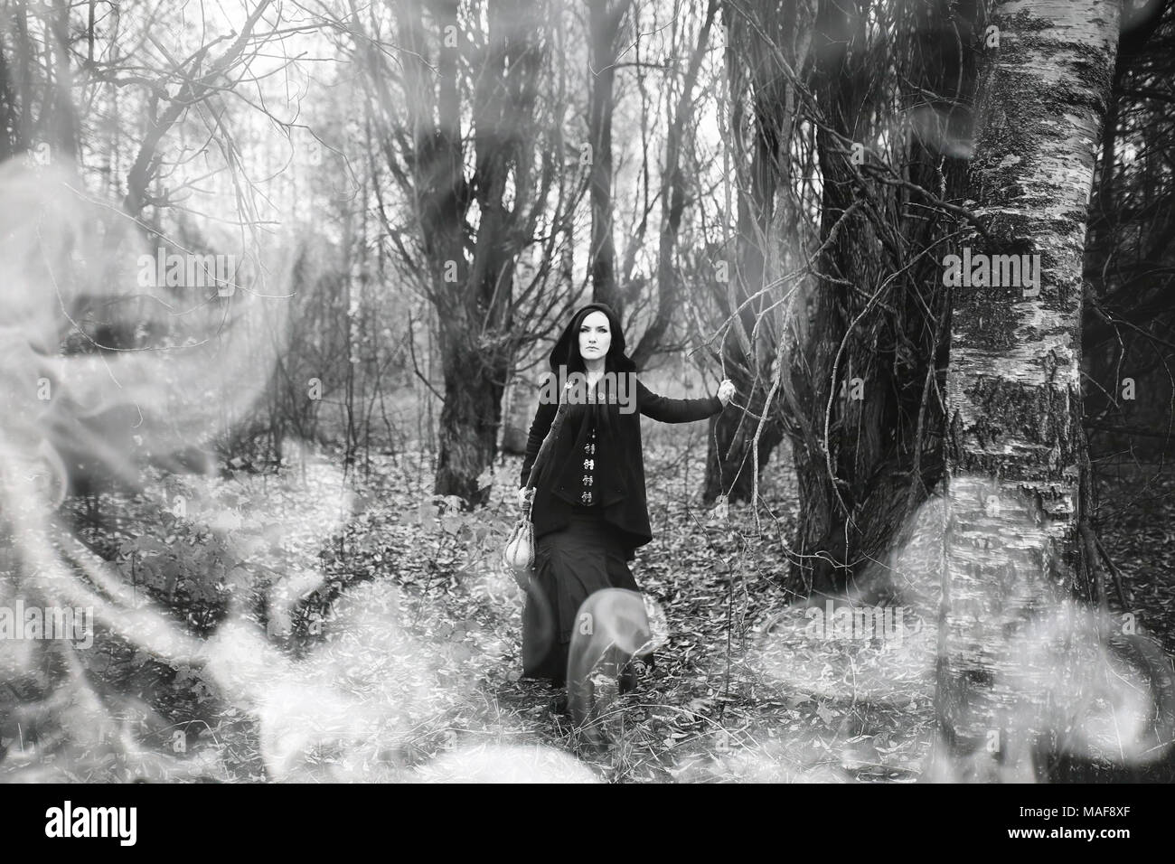 A woman in a witch suit in a dense forest on a ritual Stock Photo - Alamy