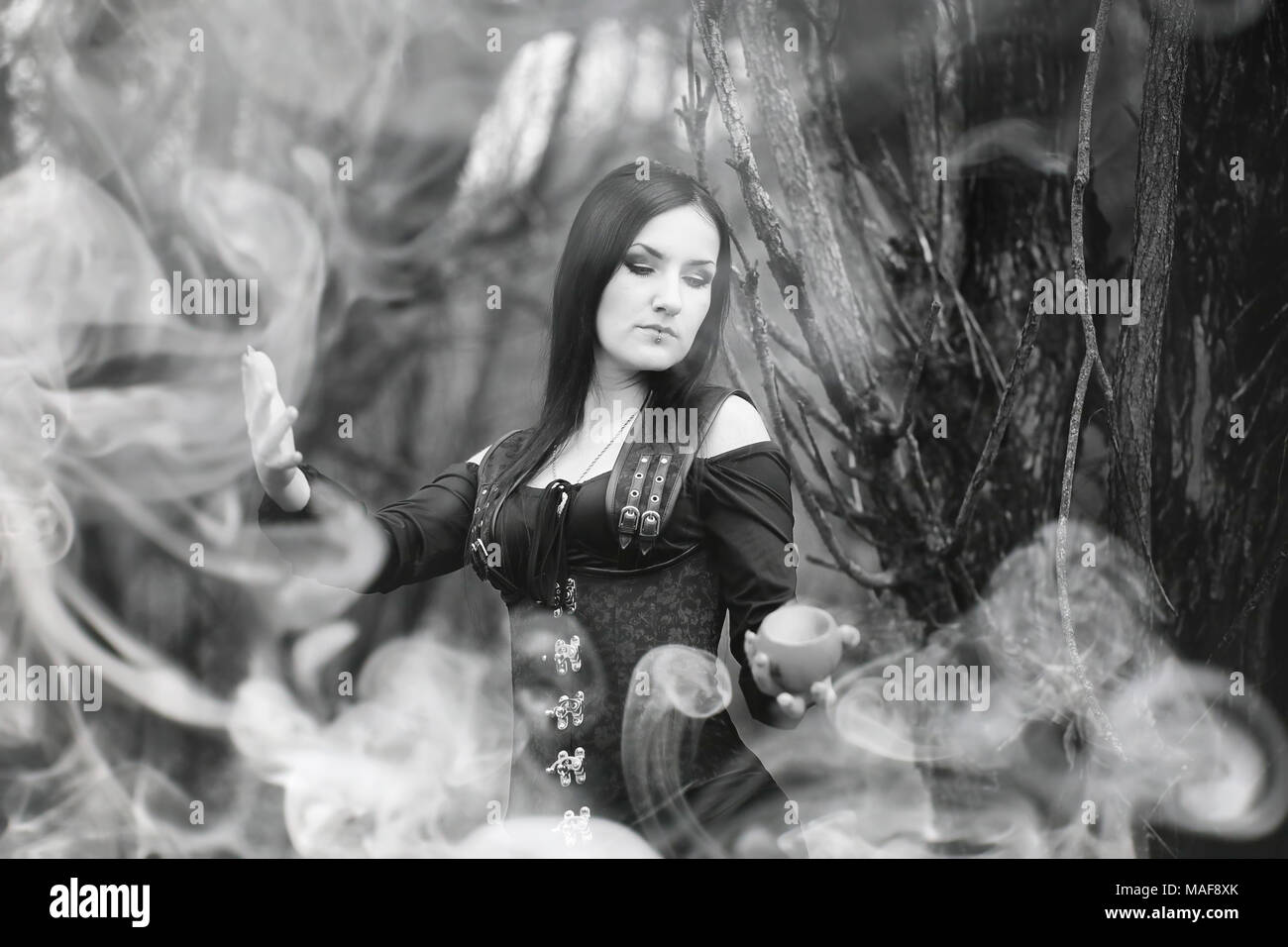A woman in a witch suit in a dense forest on a ritual Stock Photo - Alamy