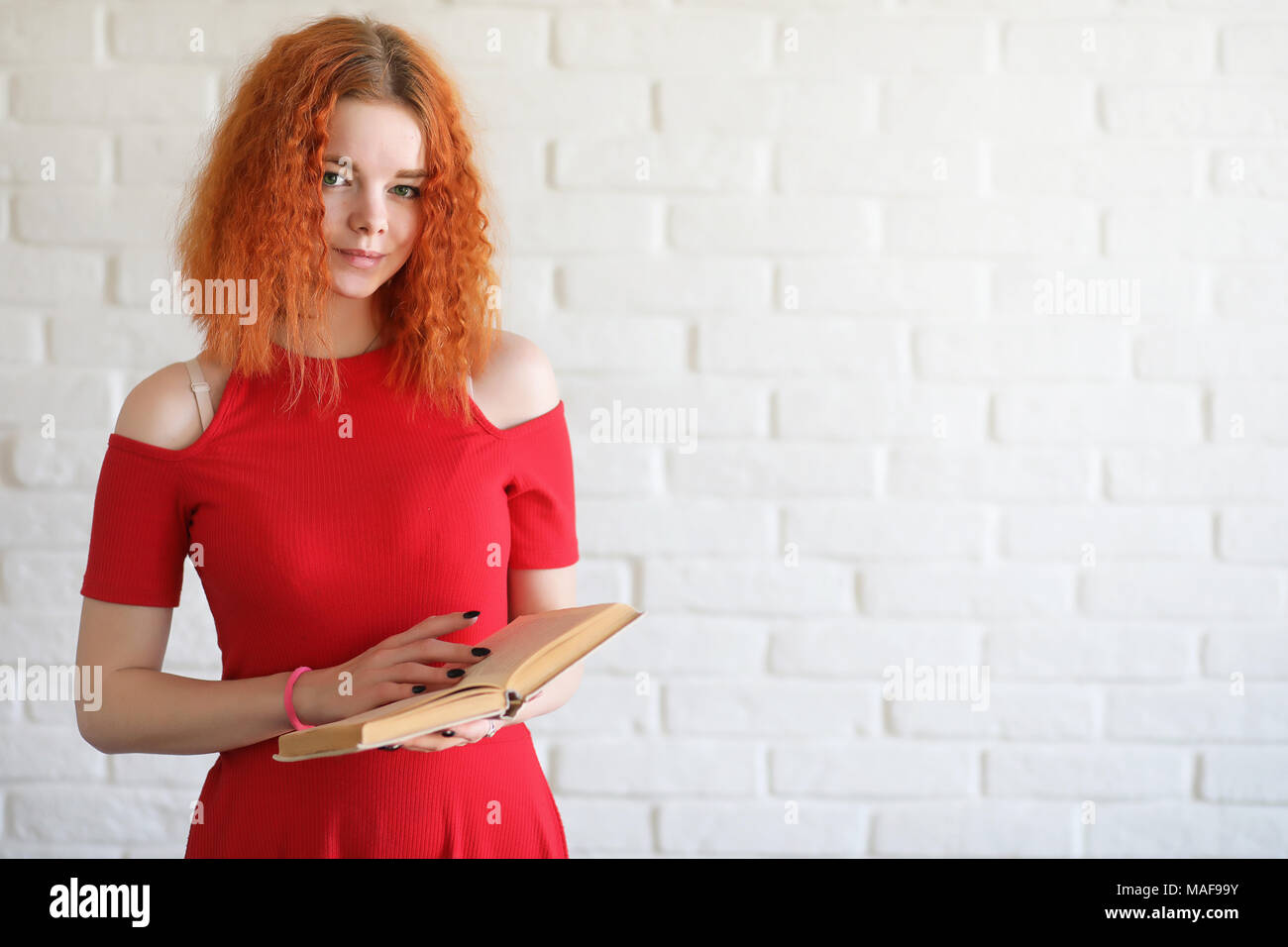 Red-haired girl student on a brick wall background Stock Photo - Alamy