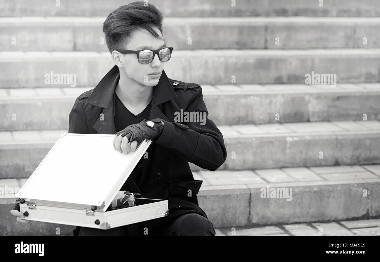 Asian man with a metal suitcase in the city. Asian and silver case ...