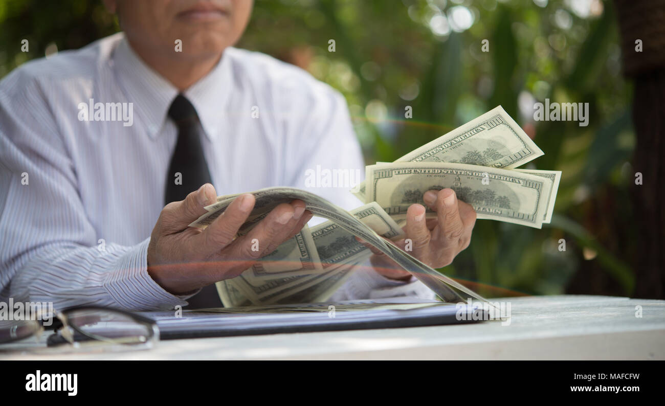 Senior businessman counting U.S. dollar bills Stock Photo - Alamy