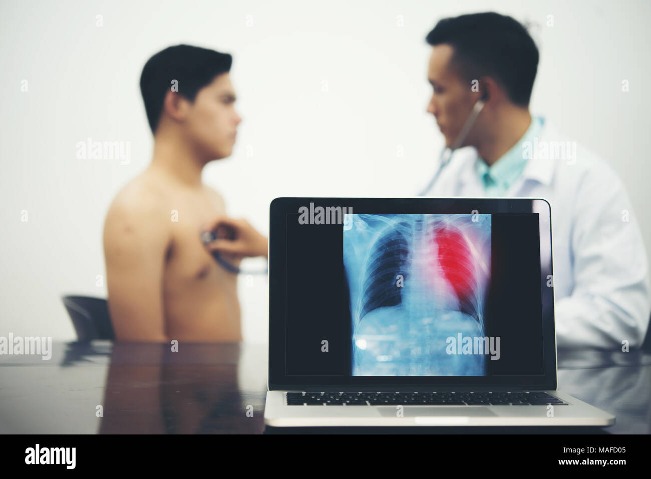 Doctor with patient at clinic with x-ray film on laptop Stock Photo - Alamy