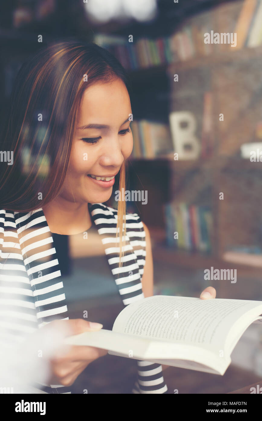 Asian woman reading a book in library Stock Photo - Alamy