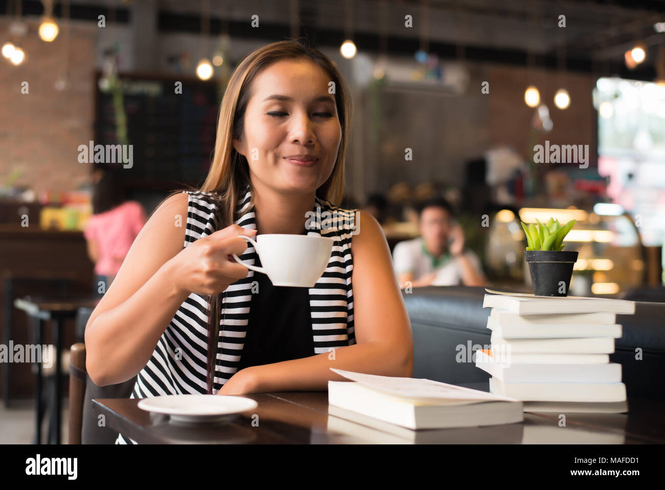 Asian woman relaxing and reading a book in the cafe. Women lifestyle ...