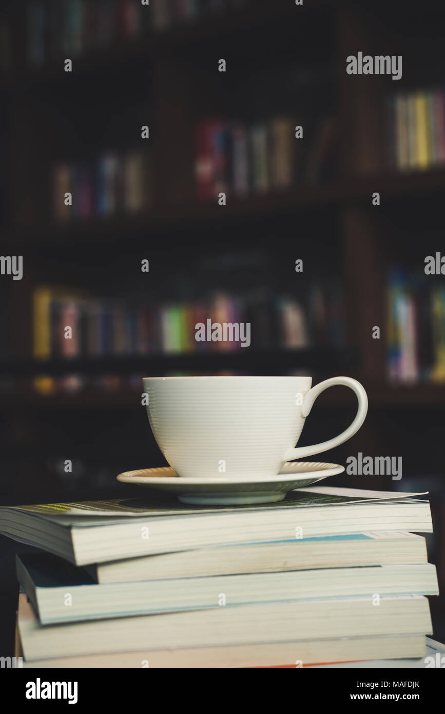 Coffee cup and stack of books on wood table. Education concept Stock ...