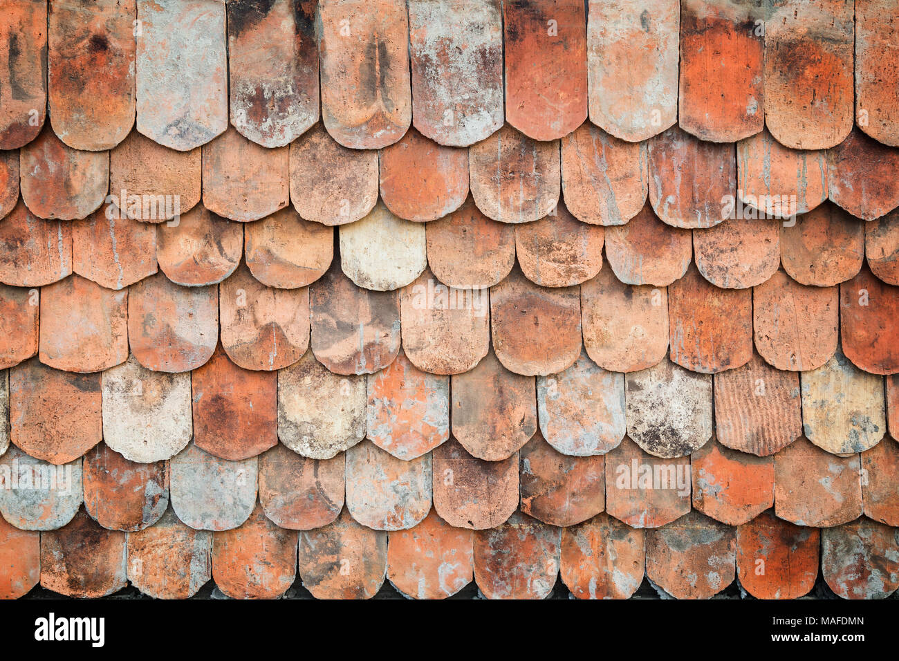 Close-up of old and weathered red roof tiles texture background with ...