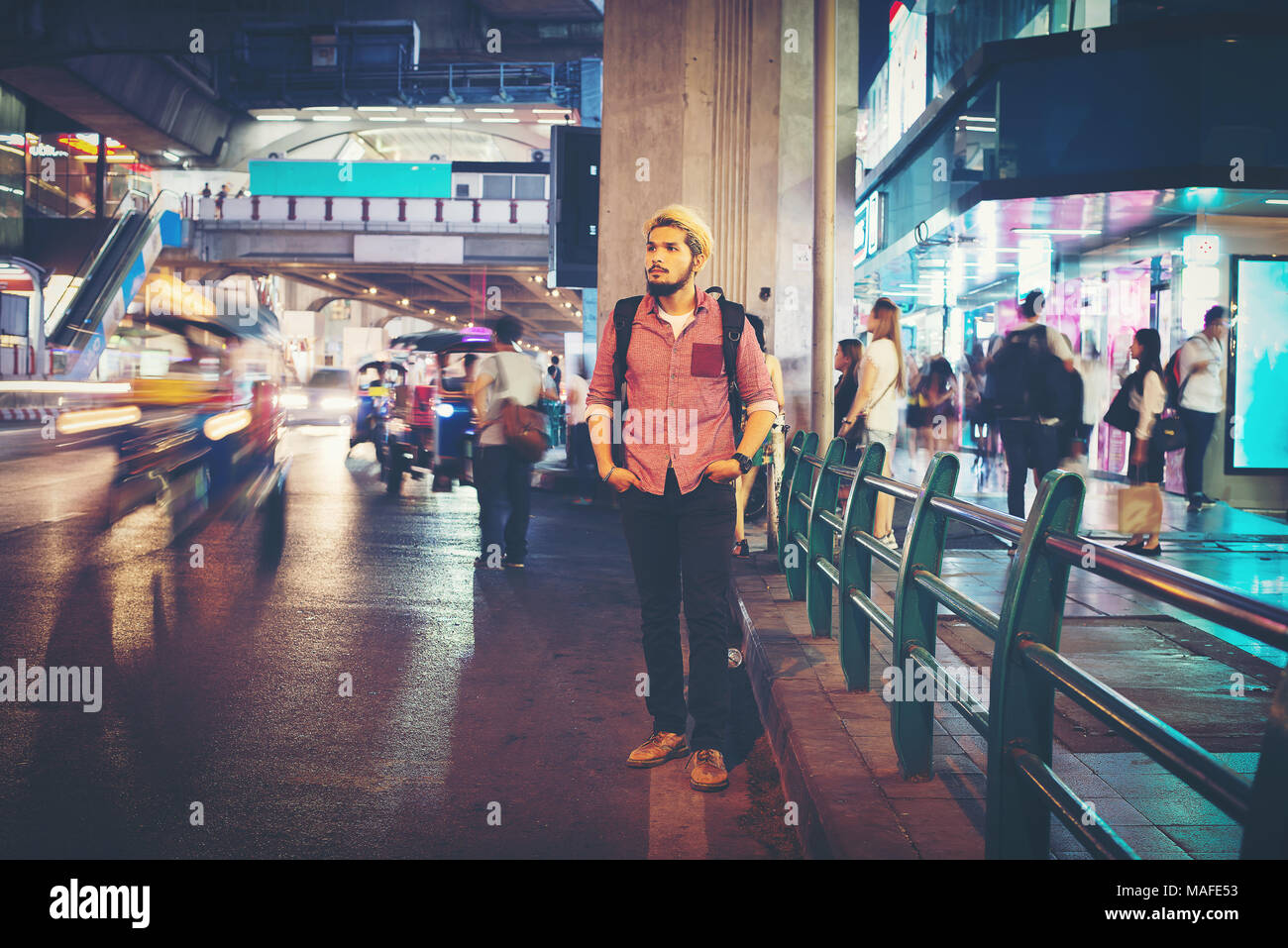 Handsome bearded man standing roadside street while traveling at night ...