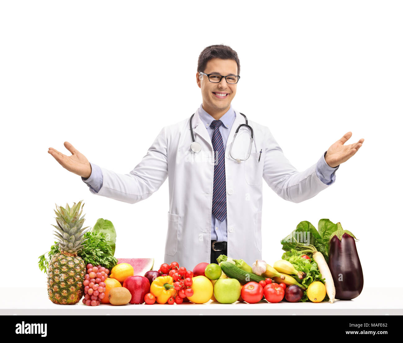 Doctor behind a table with fruit and vegetables gesturing with his ...