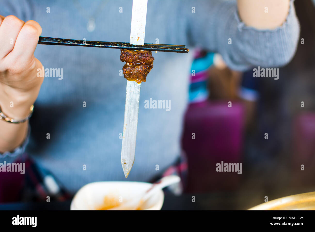 Woman taking barbeque from a stick close up Stock Photo - Alamy