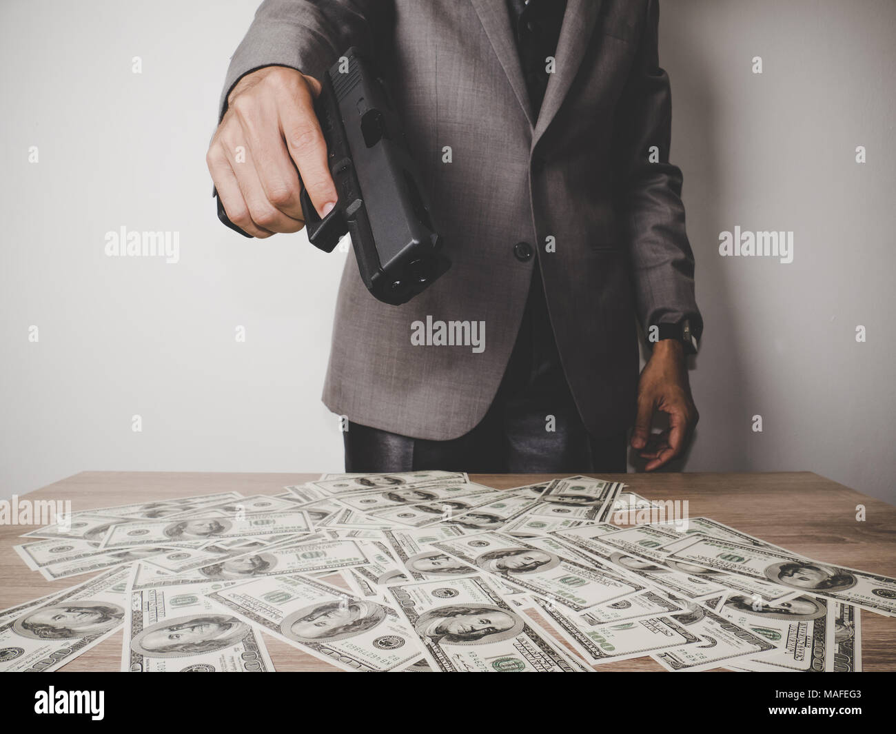 Gangster man hand holding a gun with dollar banknote Stock Photo - Alamy