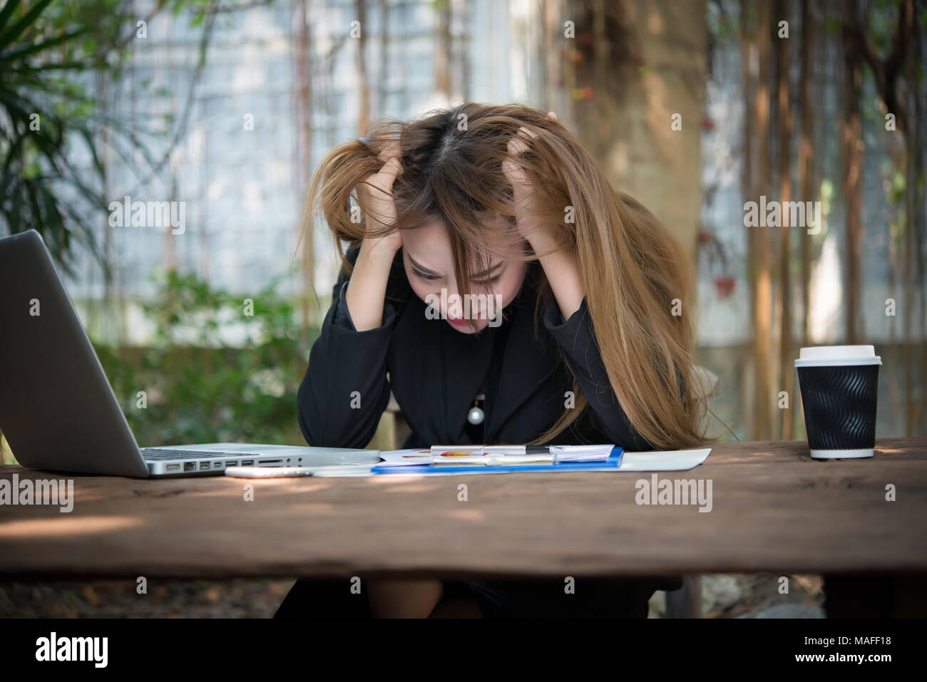 Portrait of a stressed out business woman at her workplace. She is ...