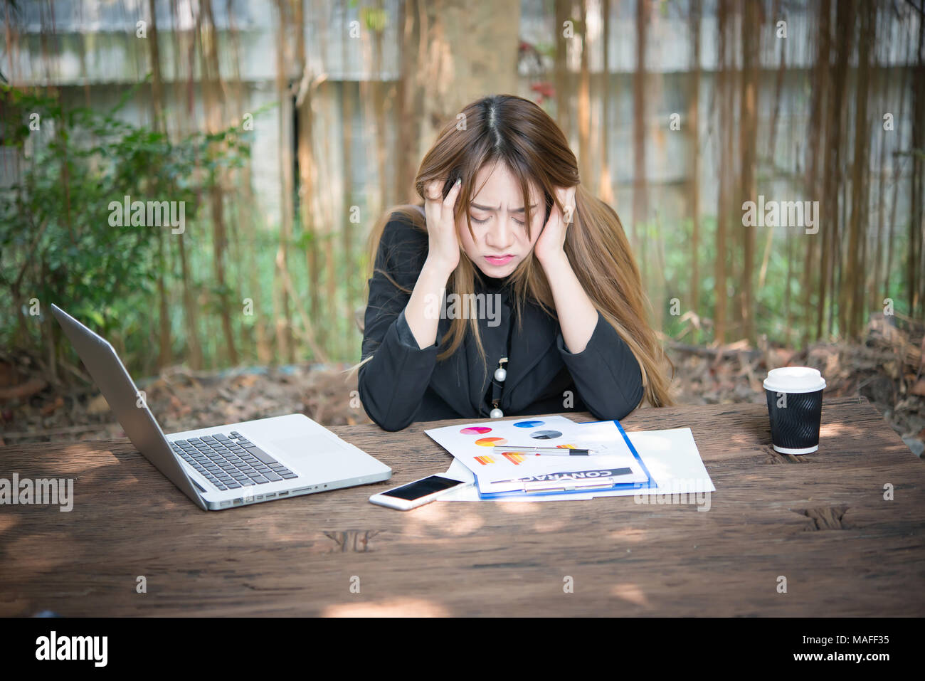 Portrait of a stressed out business woman at her workplace. She is ...